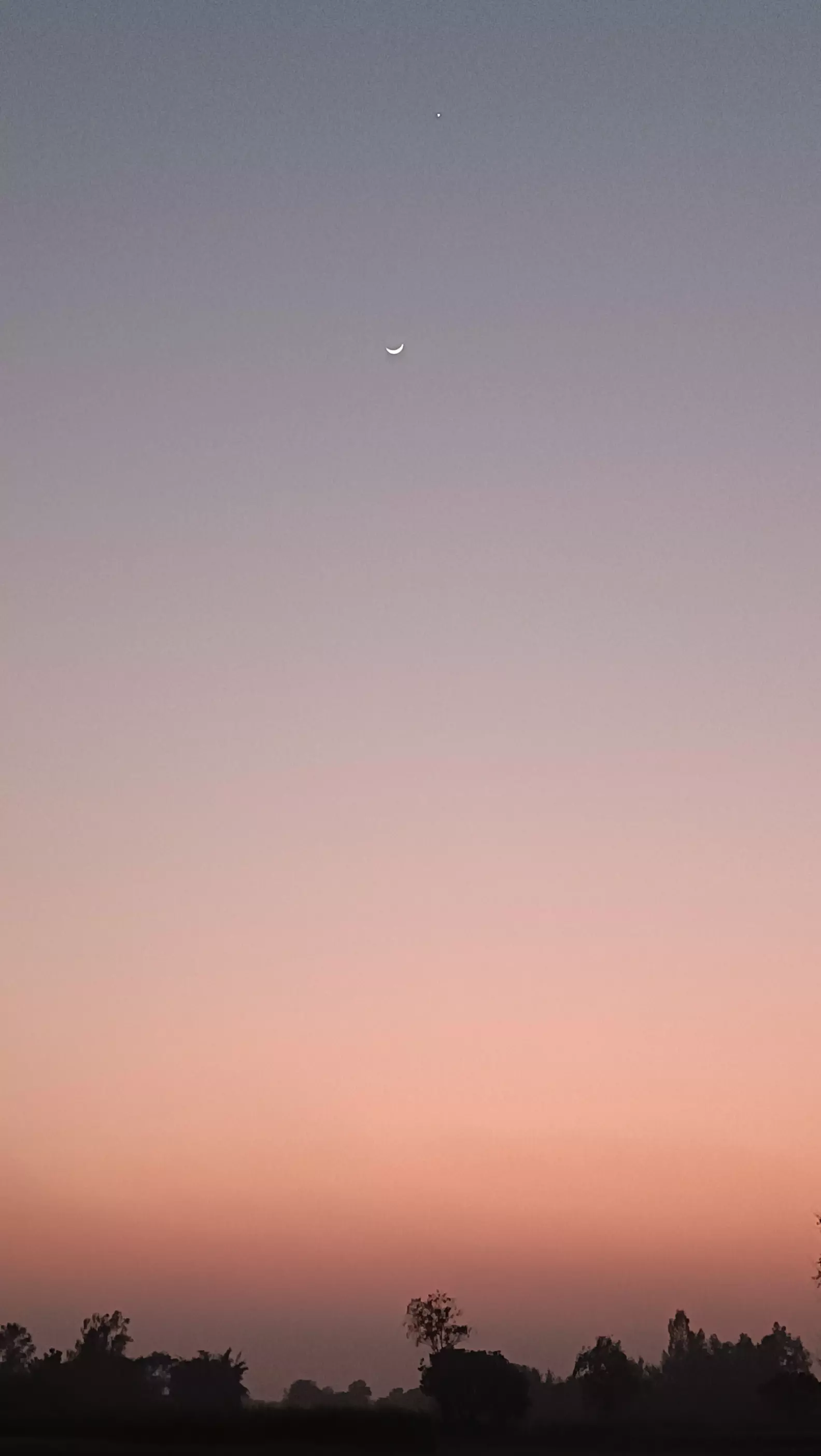 After sunset the moon appears in the sky and clouds gets ora