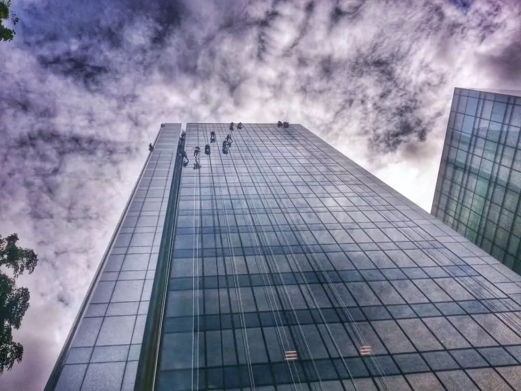 Rappellers on the exterior of a high rise building performin