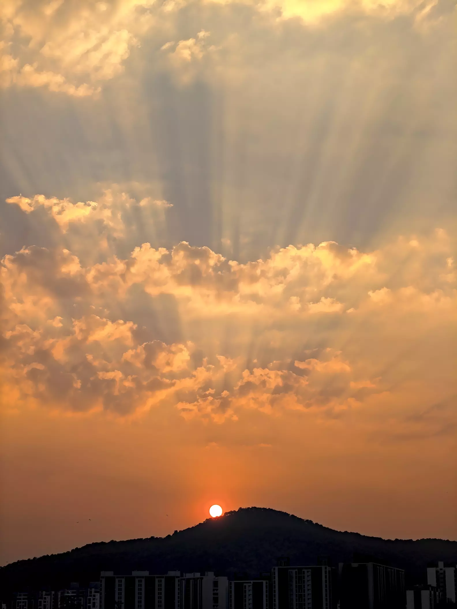 Golden hour serenity over a silhouetted hill, with dramatic